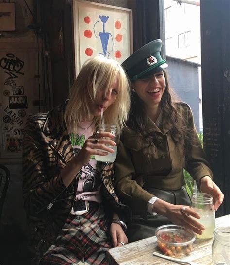 Two Women Enjoying Drinks At A Table