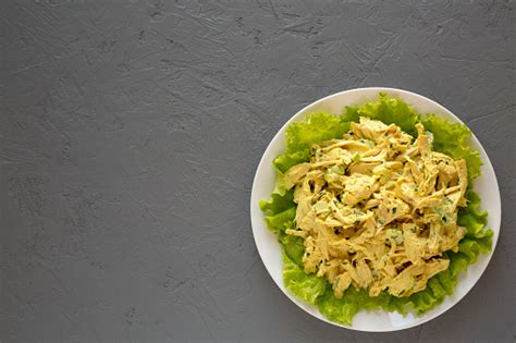 회색 배경의 흰색 접시에 집에서 만든 대관식 치킨 샐러드 오버 헤드 보기 플랫 레이 위에서 상단 보기 공간을 복사합니다 0명에