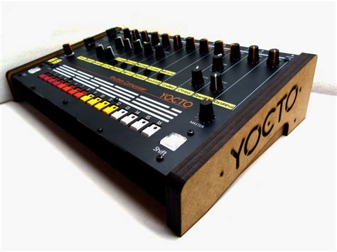 An Electronic Mixing Board Sitting On Top Of A White Surface With Black And Yellow Numbers