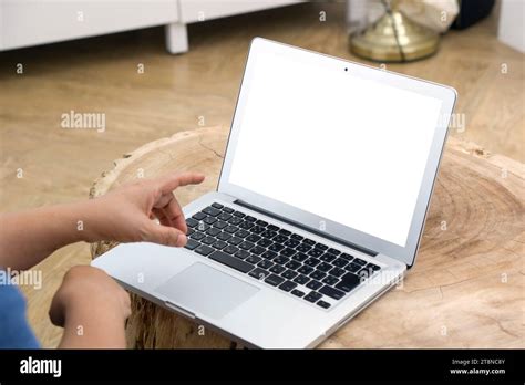 An Individual Engrossed In Work On A White Screen Laptop The Laptop Is Perched On A Richly