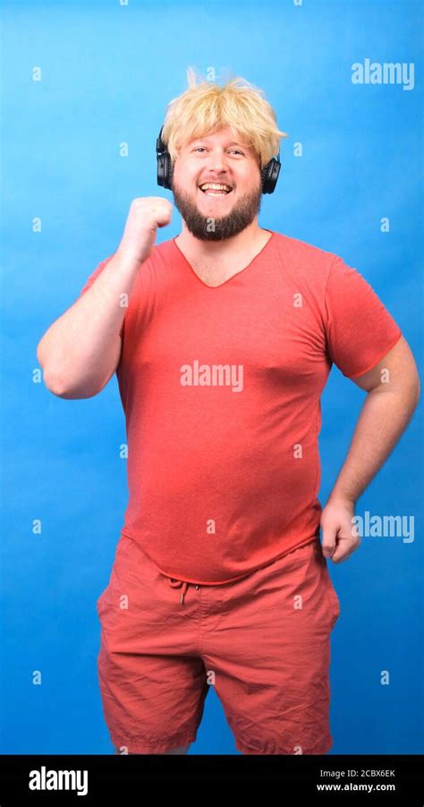 Funny Chubby Freak Man In Headphones And A Wig In A Pink T Shirt Dances