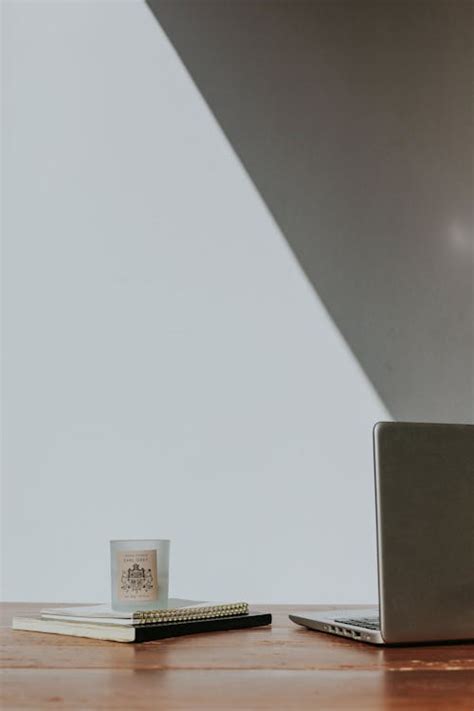 노트북과 캔들로 구성된 미니멀리스트 홈 오피스 책상 세팅 · 무료 스톡 사진