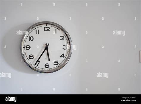 Analog Clock On A Minimalist Wall With Clear Numbers And Hands Showing Time Simple And
