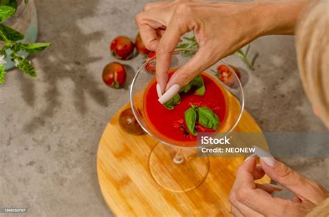 신선한 수제 생 유기농 레드 토마토 주스와 녹색 바질 잎 대나무 접시에 유리로 제공됩니다 최소한의 유기농 야채 개념 개념에 대한