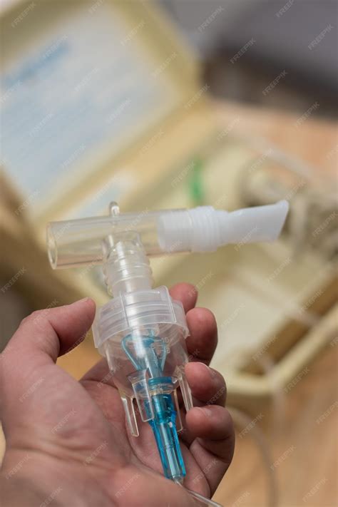 Premium Photo Vertical View Of Hand Holding A Nebulizer Steam Tube