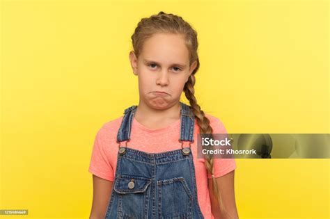재미 좌절 장난 꾸러기 어린 소녀의 초상화와 코믹 분개 불행한 얼굴 표정으로 카메라를보고 땋은 머리에 대한 스톡 사진 및 기타