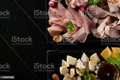 경화 고기와 치즈의 다른 종류와 샤퀴테리와 치즈 보드 훈제 고기 는 검은 접시를 Ot 맛있는 파마산 도르블루 부드러운 치즈