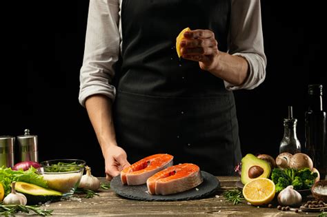 요리사는 신선한 생선 연어 송어 레몬 야채와 물을 준비 합니다 가로 사진입니다 개념 건강 요리 및 채식 요리 레스토랑 호텔