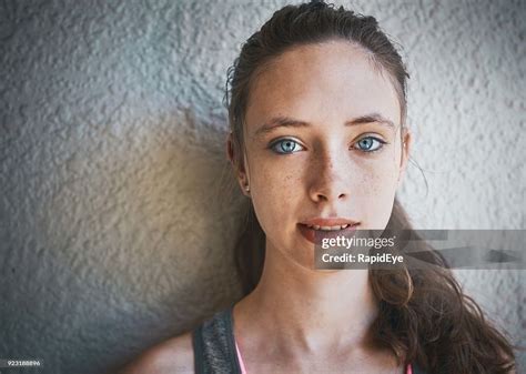 Beautiful Blueeyed Brunette Standing By Textured Wall Daydreaming High