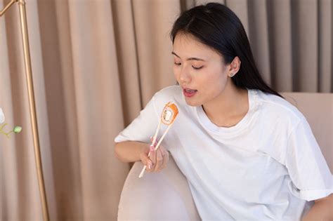 아시아 뷰티 모델 소녀 먹는 스시 롤 건강 한 일본 음식 필라델피아 롤과 젓가락을 들고 있는 아름다운 여자 20 24세에 대한