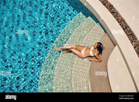Top View Of Young Slim Woman In White Bikini Relaxing In Swimming Pool