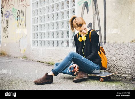 Young Beautiful Caucasian Woman Skater Sitting On Her Skate With