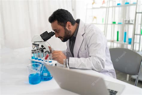 Premium Photo Lab Worker Using Magnifying Glass On Microscope