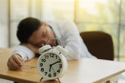 Empresario cansado durmiendo en la mesa hasta la mañana Foto Premium
