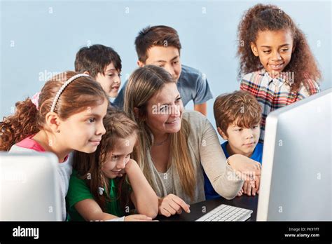 Pupils Group Learns Together On The Computer In The Internet Class
