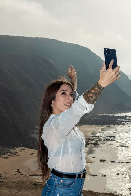 Premium Photo Excited Woman Taking A Selfie While Standing On The