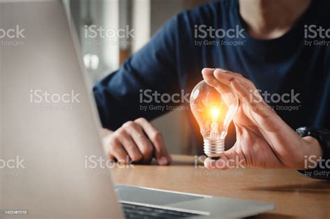 가까이서 손은 인적 자원 또는 리더십 및 창의력 사고 아이디어 동기 부여 또는 비전 및 지식 학습에 밝은 전구 또는 램프를