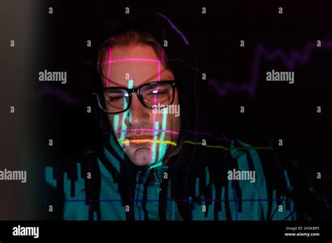 displeased hacker with charts reflection looking down on black