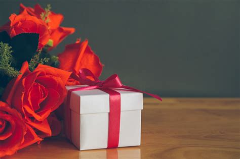 핑크 리본으로 포장 하는 작은 선물에 빨간 장미 나무 테이블에 배치 발렌타인 선물입니다 0명에 대한 스톡 사진 및 기타 이미지