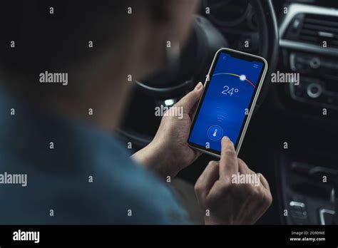 Woman Operating Temperature Through Smart Phone In Car Stock Photo Alamy