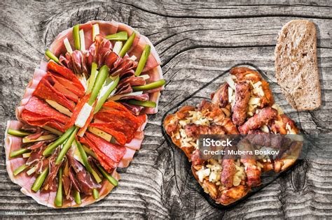 전통적인 장식된 전채 요리 Meze 구운된 다진된 고기 덩어리 Cevapcici와 브라운 빵의 조각으로 매듭 짓된 소나무 목재 피크닉 테이블에 닭 허벅지 0명에 대한 스톡