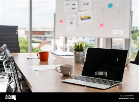 Laptop Computer With Opened Lid On Table In Meeting Room Of Office
