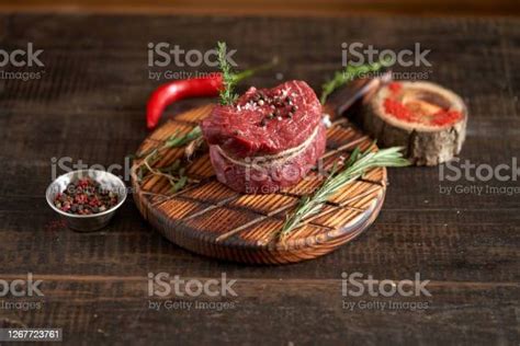 완두콩 말린 토마토 파프리카 나무 표면에 붉은 칠리 신선한 육즙 숙성 필렛 미뇽 스테이크향신료와 도마에 꼬기로 묶여 상단 보기
