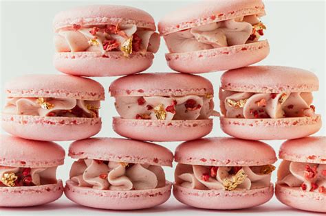 황금 꽃잎으로 장식 된 분홍색 딸기 마카롱과 동결 건조 된 빨간 열매가 피라미드 모양으로 함께 쌓여 있습니다 흰색 배경 클로즈업 샷 금색에 대한 스톡 사진 및 기타 이미지