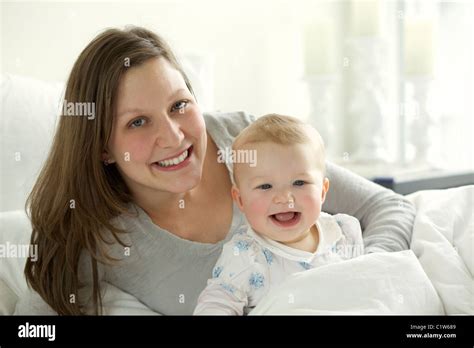 Portrait Of A Happy Mother Hugging Her Baby While Relaxing In Bed Stock Photo Alamy