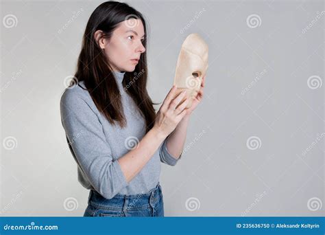 A Young Woman Hides Her Face Behind A Mask The Concept Of