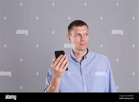 Man Unlocking Smartphone With Facial Scanner On Grey Background Biometric Verification Stock