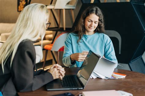 한 여성 고객이 디자인 선택에 대해 관리자와 상의합니다 두 명의 여성 사업가가 일하고 있습니다 2명에 대한 스톡 사진 및 기타 이미지 Istock