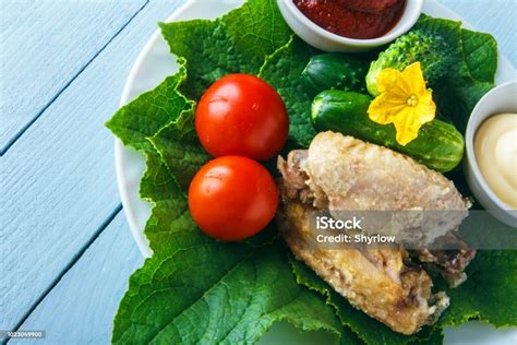 녹색 오이에 신선한 요리 맛 있는 닭고기 날개 흰 접시에 유기농 토마토와 함께 떠난다 나무 테이블에 위에서 볼 공간 복사 0명에