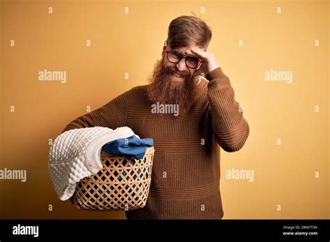 Redhead Irish Man With Beard Doing Housework Laundry Over Yellow