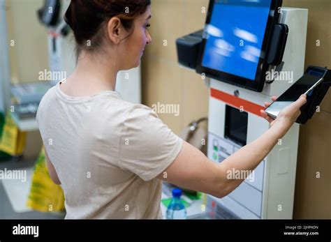 Woman Paying With Smartphone In Store At Self Checkout Counter Stock Photo Alamy