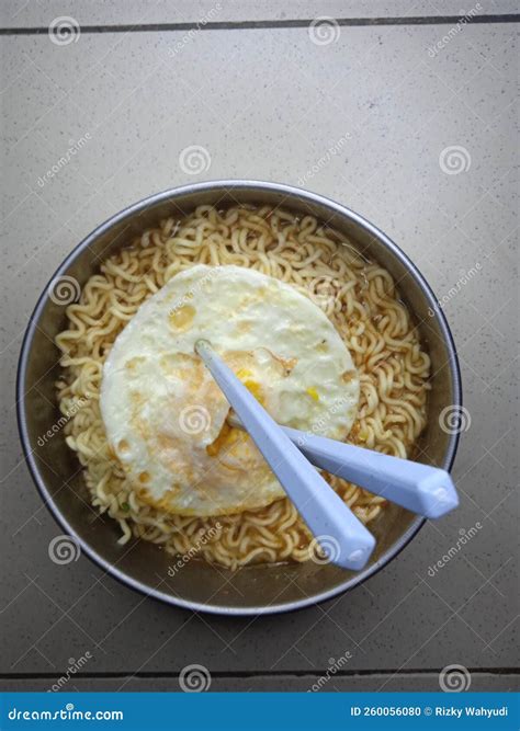Fried Chicken Eggs Stuck With Blue Chopsticks On A Pile Of Instant