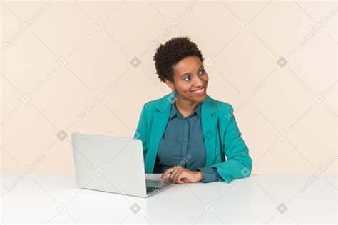 노트북에서 작업하고 옆으로 보는 젊은 여성 사무실 직원 사진