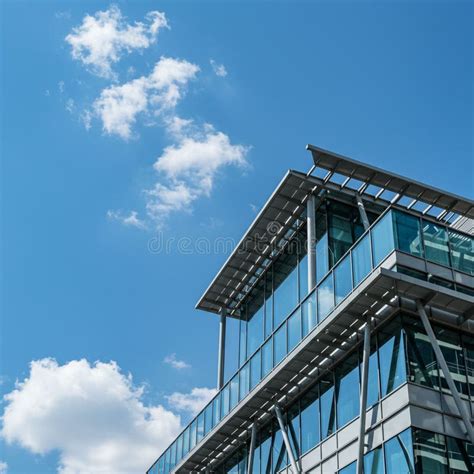 Modern Glass Building With Sleek Angular Design Features Metallic Framework And Stock