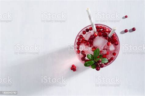 흰색 나무 테이블에 태양 광선에 붉은 링곤 베리 얼음과 빨대를 가진 가을 신선한 과일 음료 복사 공간 상단 보기 가벼운에 대한