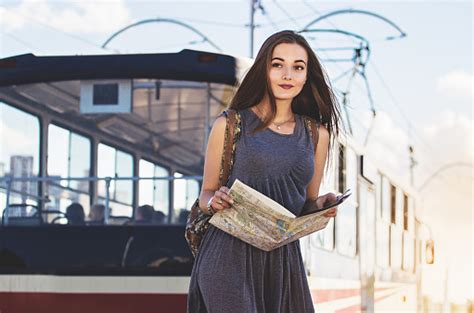 예쁜 도시 여행자입니다 멀리 보고 및 배경에 기차와 기차에 서 있고 있는 동안 손에 지도 유지 하는 드레스에 아름 다운 젊은 여자의 수평 쐈 어 거리에 대한 스톡 사진 및