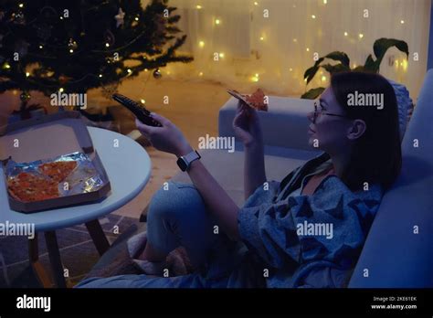 Happy Woman Eating Pizza Alone While Watching Tv At Christmas On