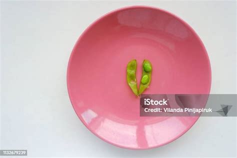 부엌 방에서 빈티지 화이트 테이블 배경에 고립 된 원형 파스텔 핑크 컬러 플레이트에 분할 녹색 Edamame 콩 일본의 탑 아이 뷰 조각 0명에 대한 스톡 사진 및 기타