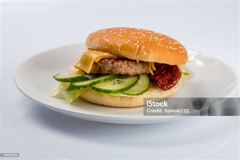 소고기 커 틀 릿 베이컨 토마토와 치즈 슬라이스를 곁들인 치즈 버거 소스와 그린 샐러드를 곁들여 흰색으로 분리 된 배경에