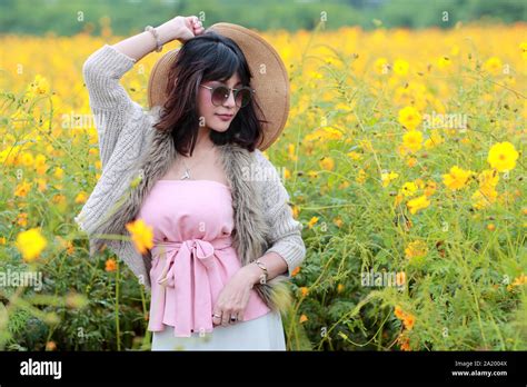 Cute And Beautiful Girl With Hat Standing In Nature Outdoors Among