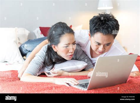 Couples Using Laptop Bedroom Stock Photo Alamy