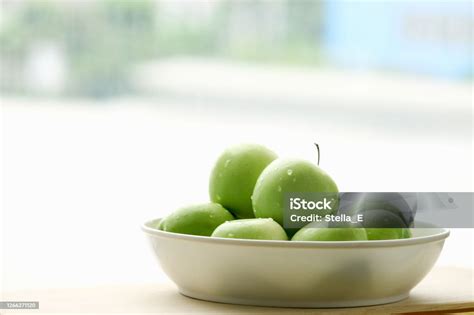 나무 테이블에 흰 그릇에 물 방울과 잘 익은 녹색 사과 생 과일 건강한 유기농 신선한 농산물 그래니스미스에 대한 스톡 사진 및