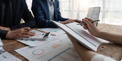 Business Team Analyzing Income Charts And Graphs With Modern Laptop