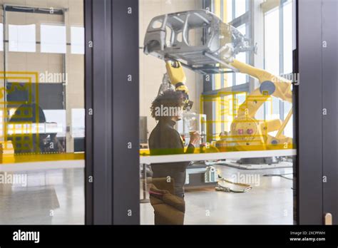 engineer in a modern robotics lab working on programming and inspecting