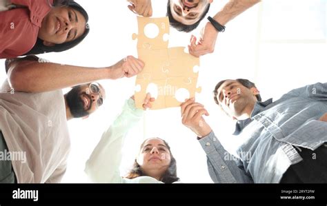 Group Of Business People Assembling Jigsaw Puzzle And Represent Team Support And Help Concept