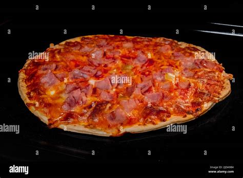 Burnt Homemade Pizza On Tray In Electric Oven Black Background Stock